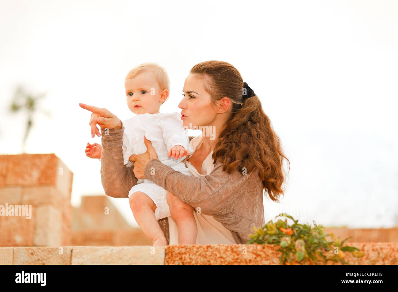 Mother showing something her interested baby Stock Photo - Alamy