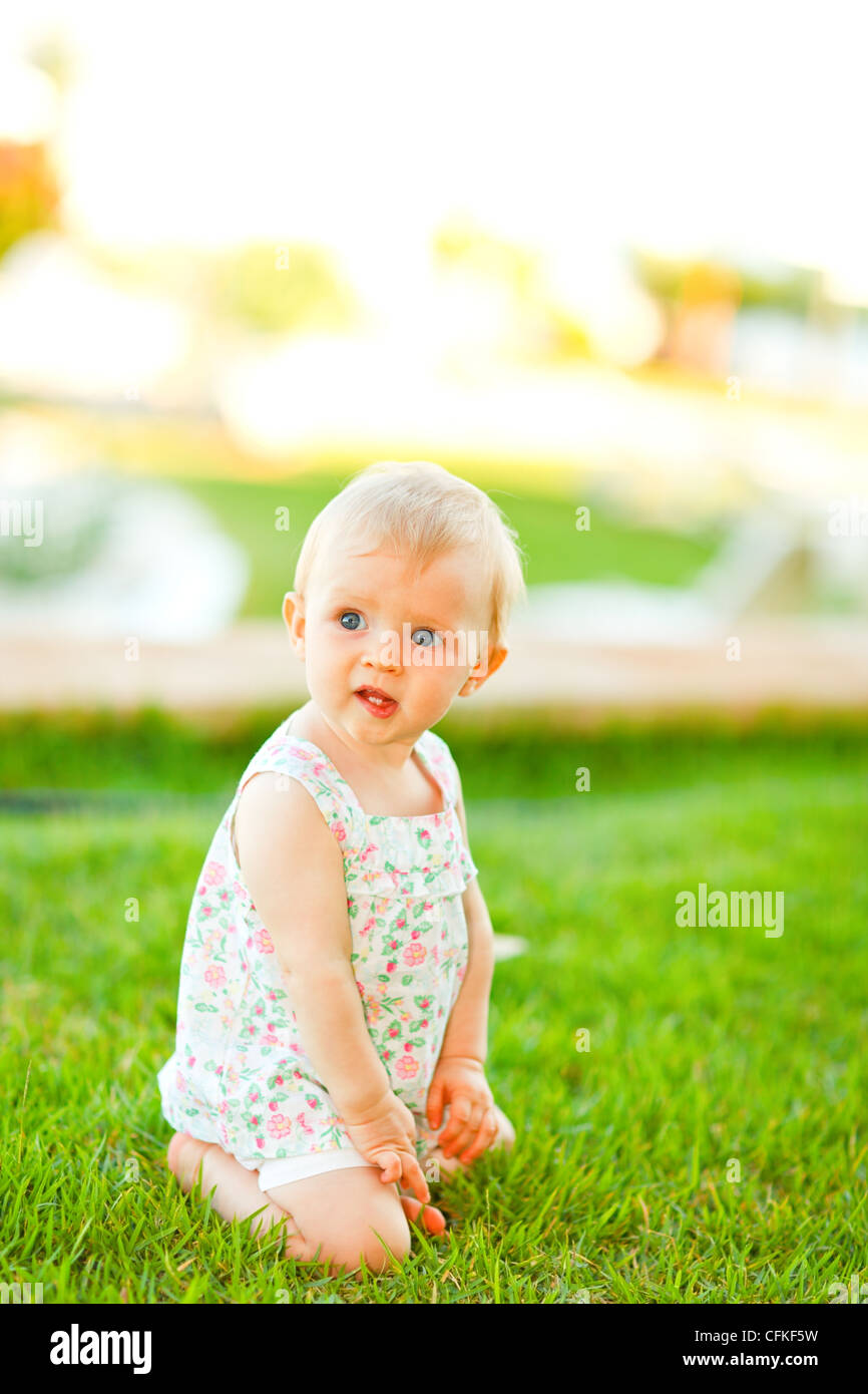Thoughtful baby playing on grass Stock Photo - Alamy