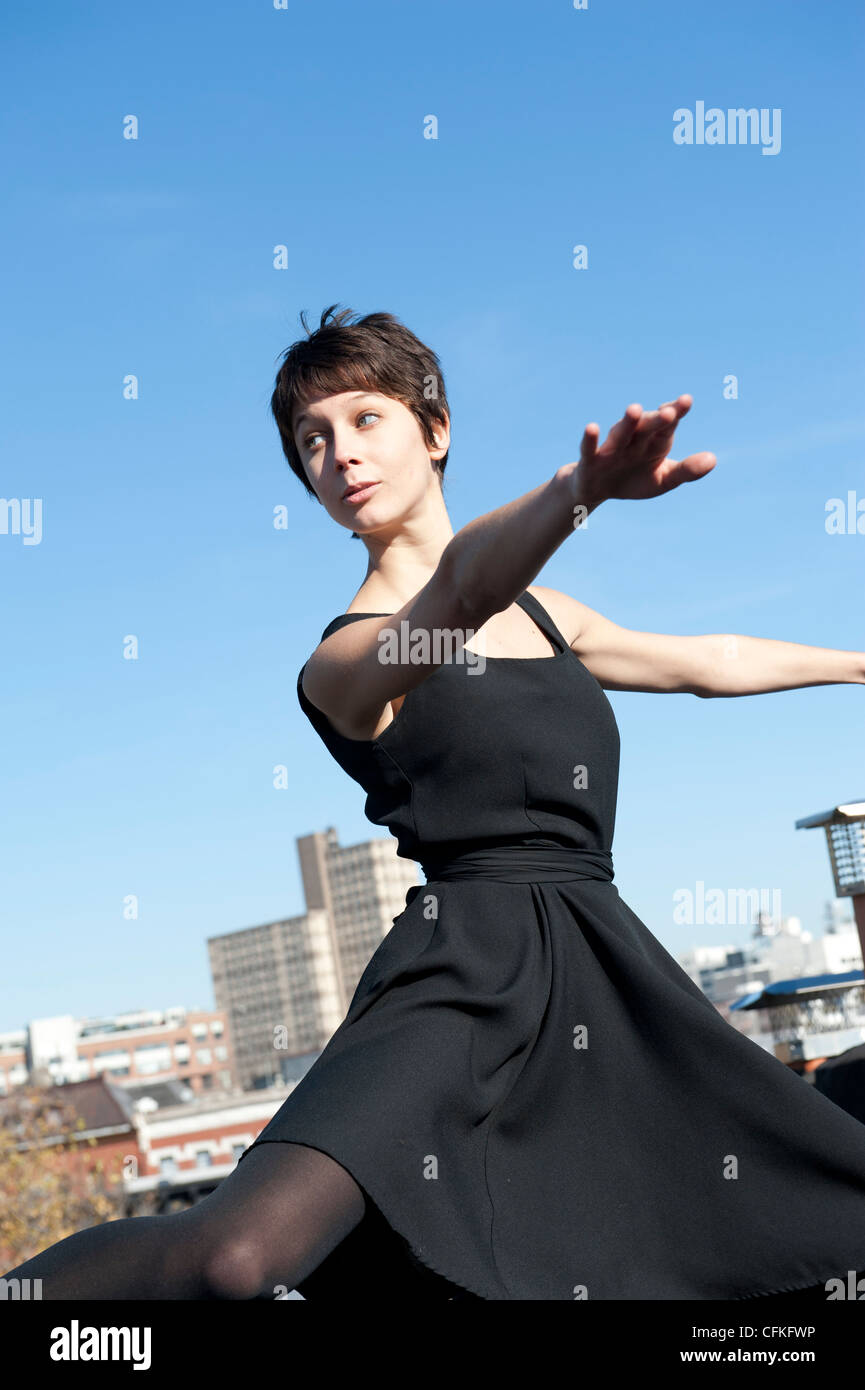 Beautiful young American woman dancing on a roof Stock Photo - Alamy