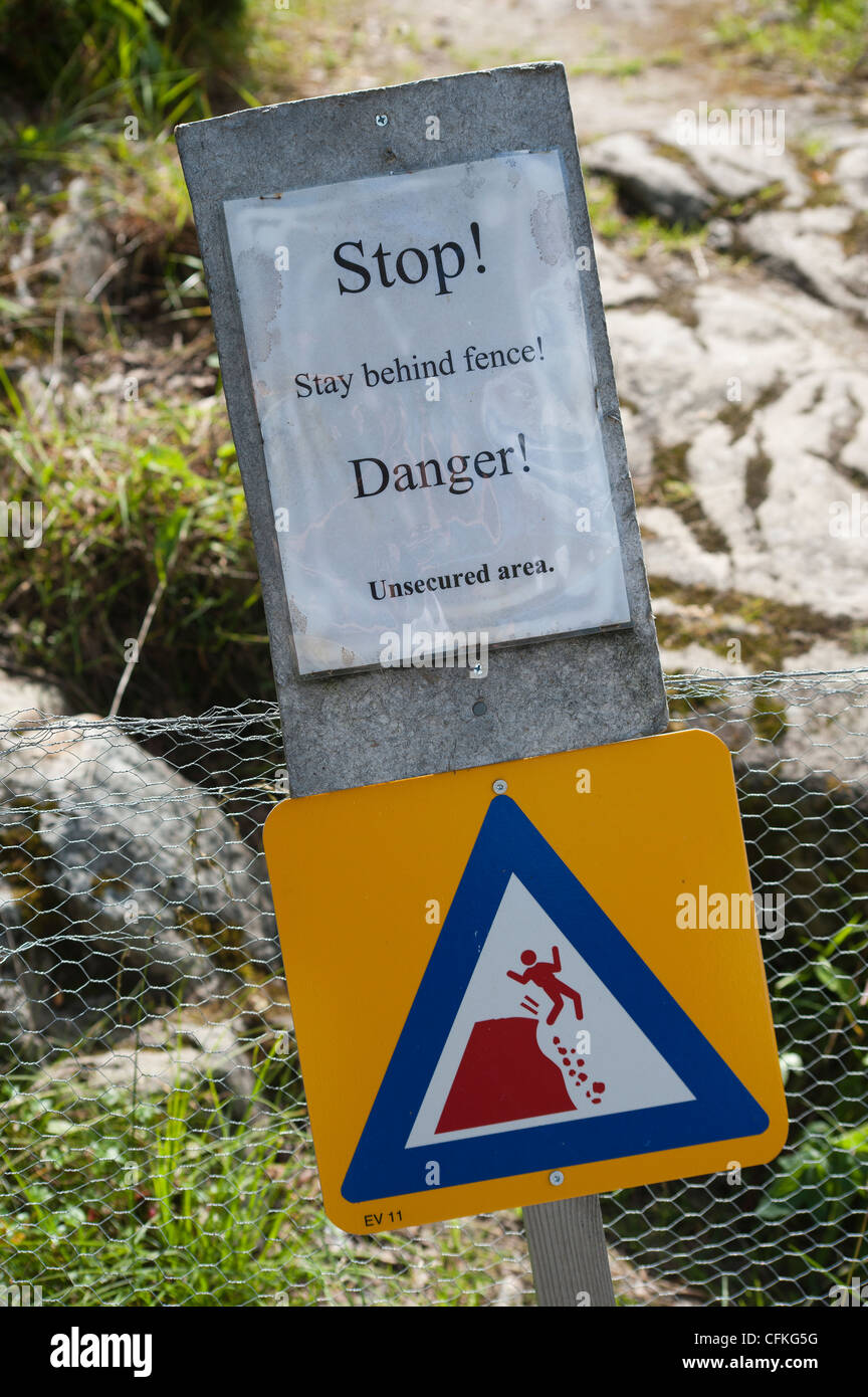 A sign warning people to stay behind the fence next to the ...