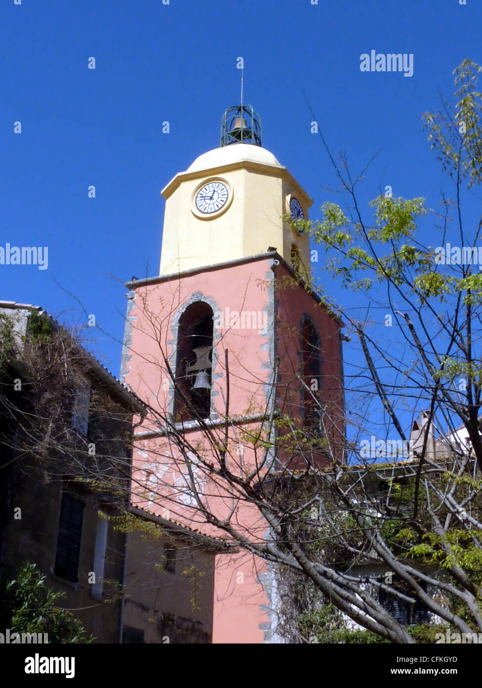 Famous pink bell tower in Saint-Tropez, France, behind branches of a ...
