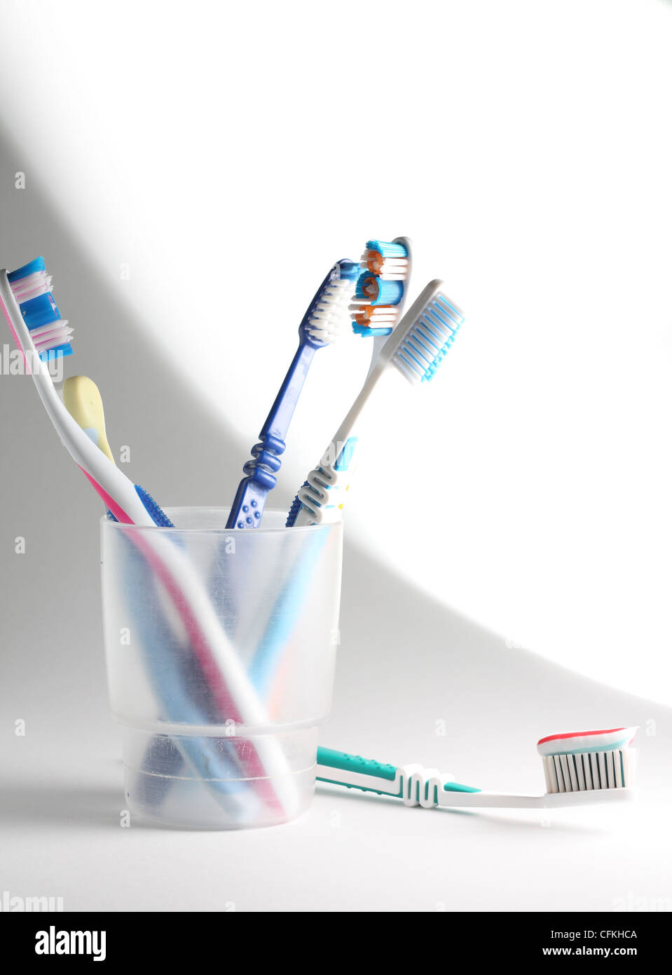 Some toothbrushes in a plastic glass Stock Photo - Alamy