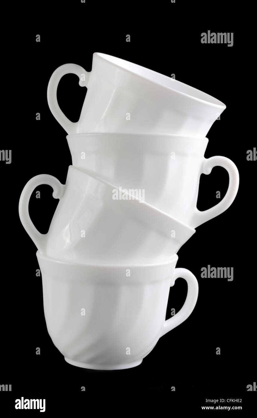 Pile of white cups isolated at the dark background Stock Photo - Alamy