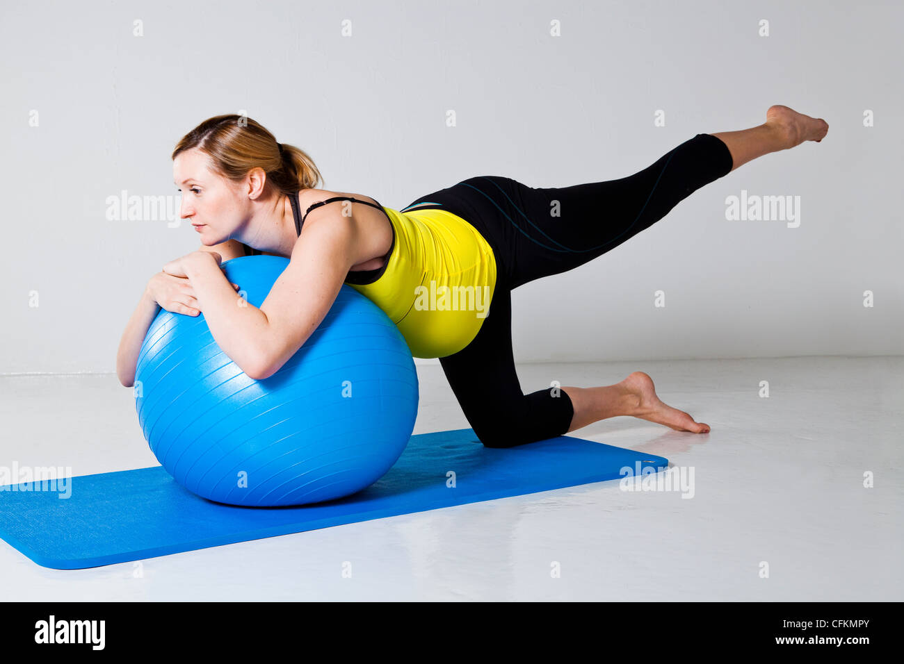 Pregnant woman doing a leg raise strengthening exercise while leaning ...