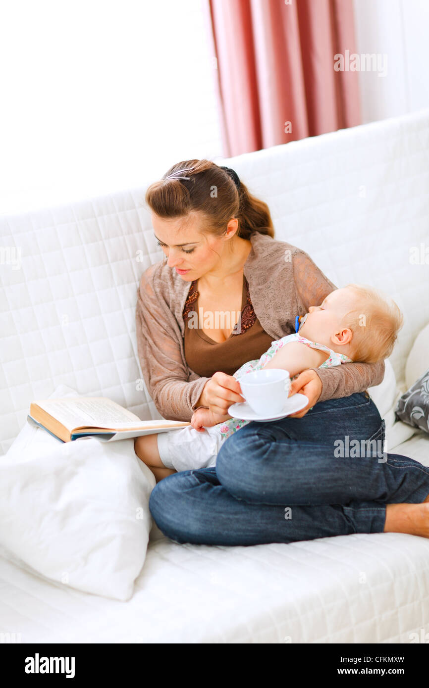 Young mom resting while baby sleep by having tea and reading book Stock ...