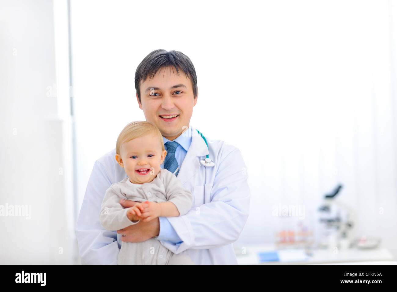 Portrait of pediatric doctor holding smiling lovely baby Stock Photo ...