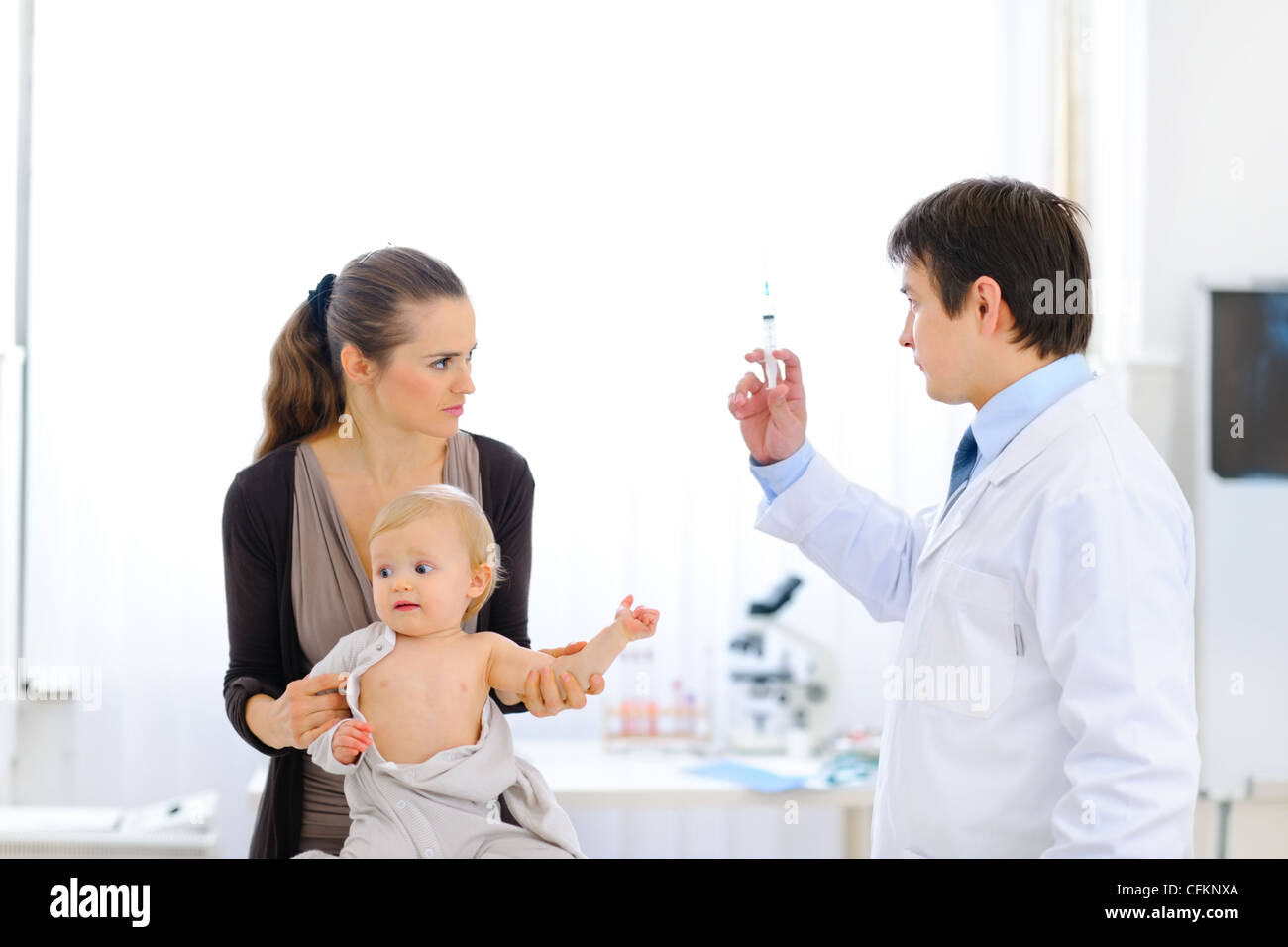 Pediatrician doctor with syringe, tense mother and unhappy baby Stock ...