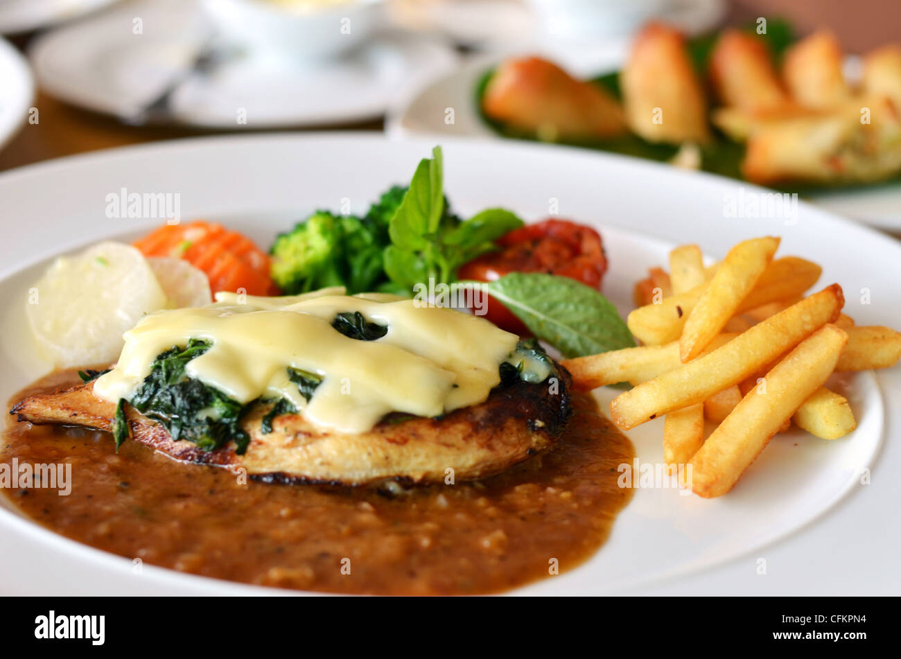 Grilled chicken steak served with chips, potatoes and vegetables Stock ...