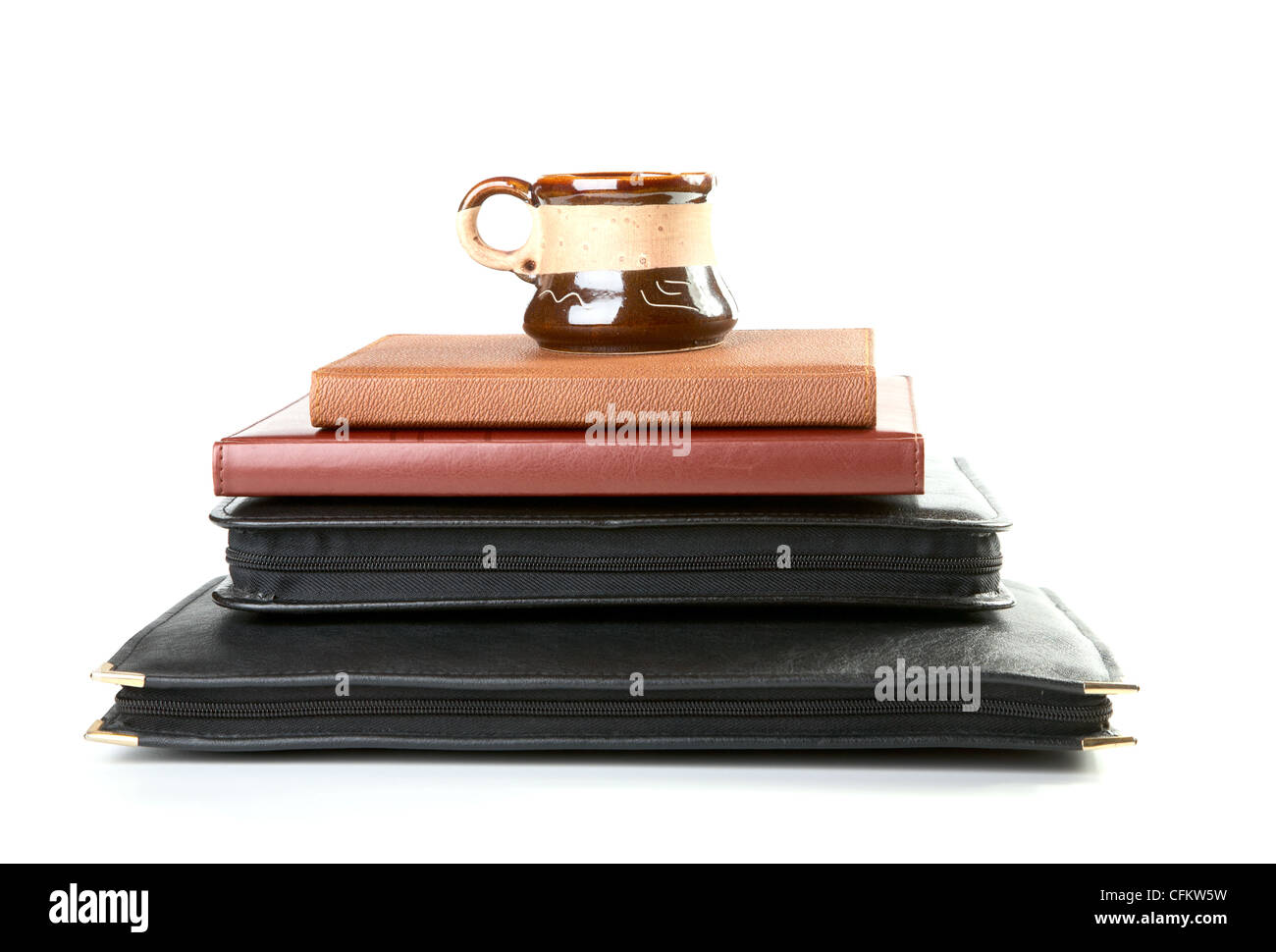Pile of folders and organizers with a coffee cup on white background ...