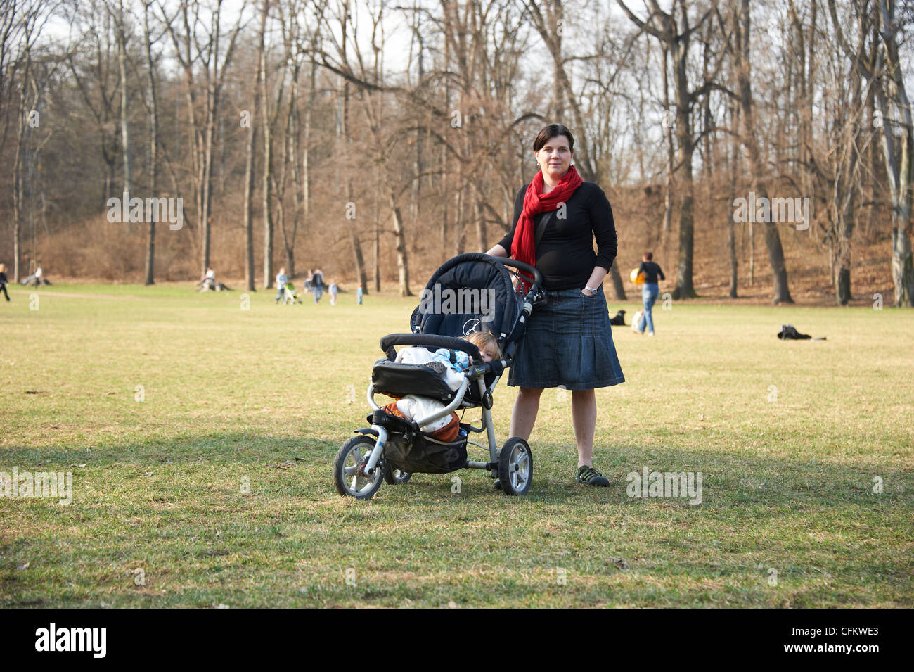 A mother with pushing pram in spring park Stock Photo - Alamy