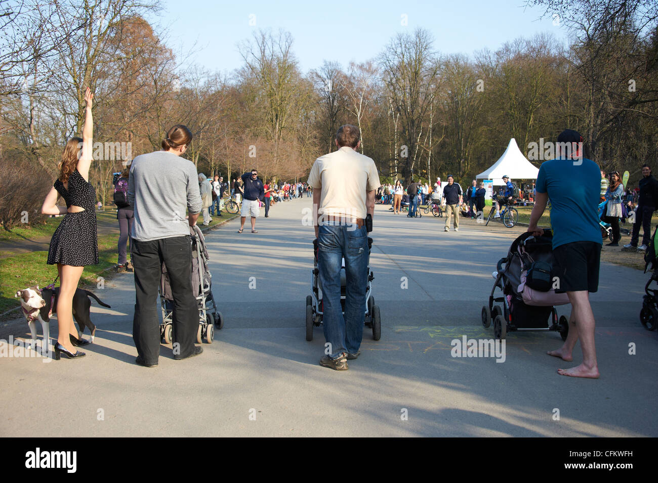 Parents running with baby in stroller in park. Strollering is ...