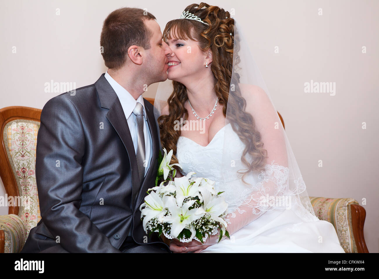 Young wedding Caucasian Russian couple. Bride kissing groom in cheek ...