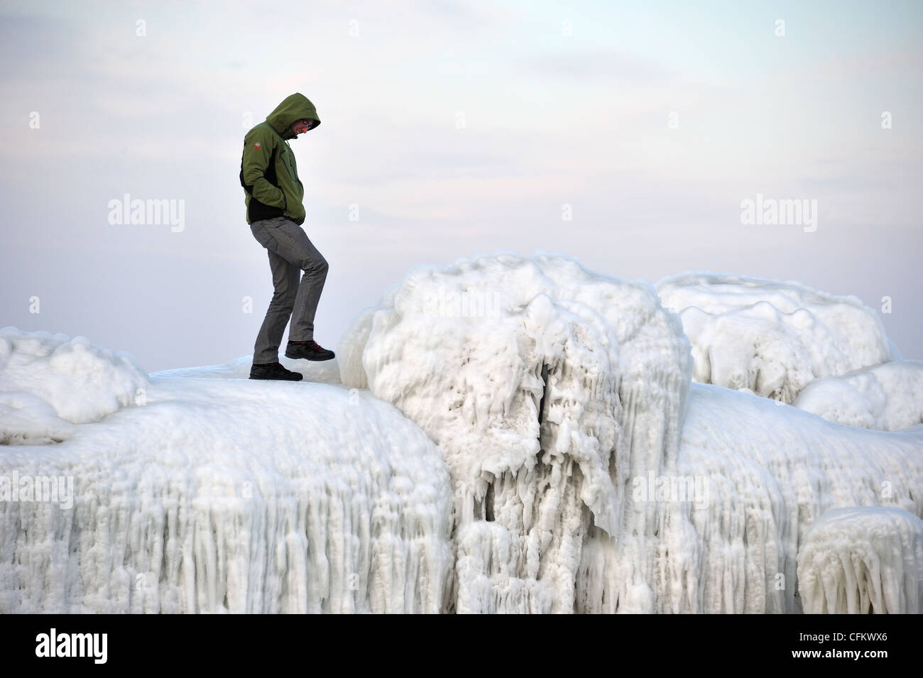 Walking on ice - a man cautiously picks his way over an icy terrain ...