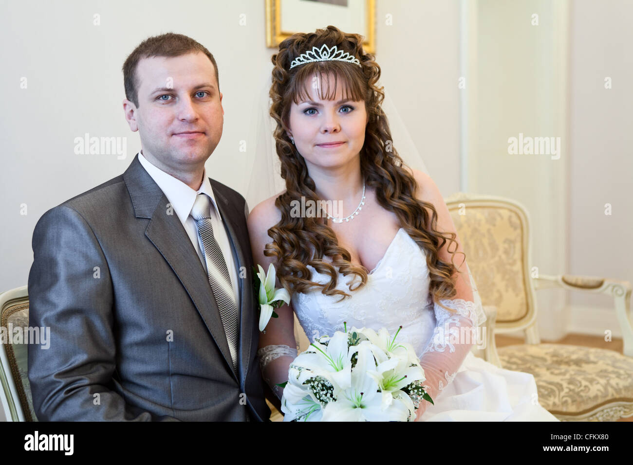 Young wedding Caucasian Russian couple. Bride and bridegroom sitting on ...
