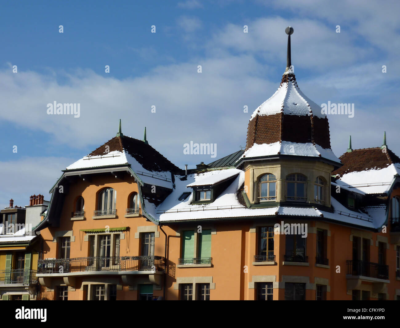 Snow on roofs of a colored building by beautiful sunny weather with ...