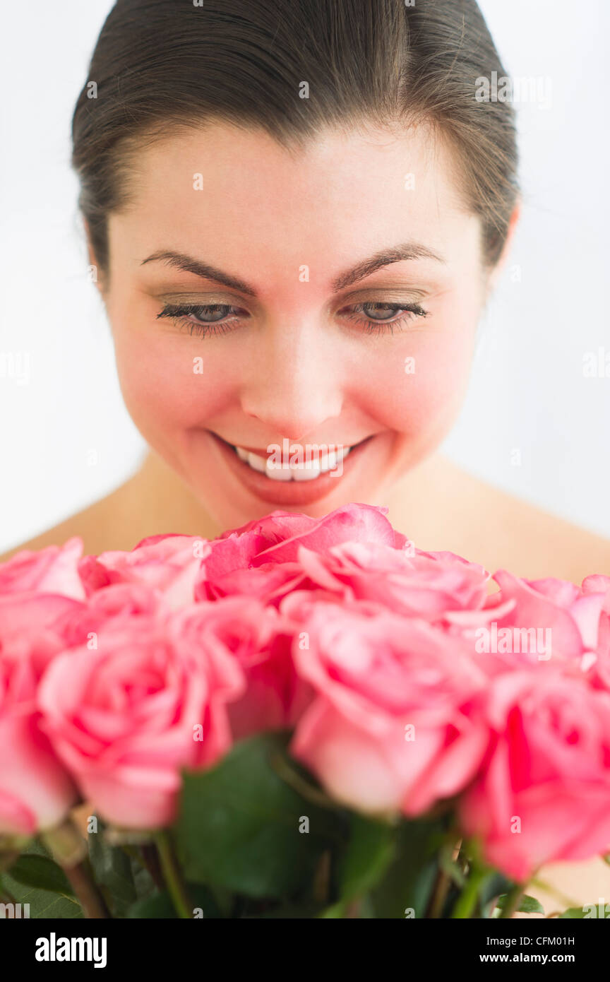 Studio shot of woman smelling roses Stock Photo - Alamy