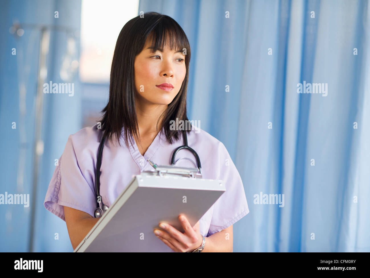 USA, New Jersey, Jersey City, Doctor noting in medical chart of ...