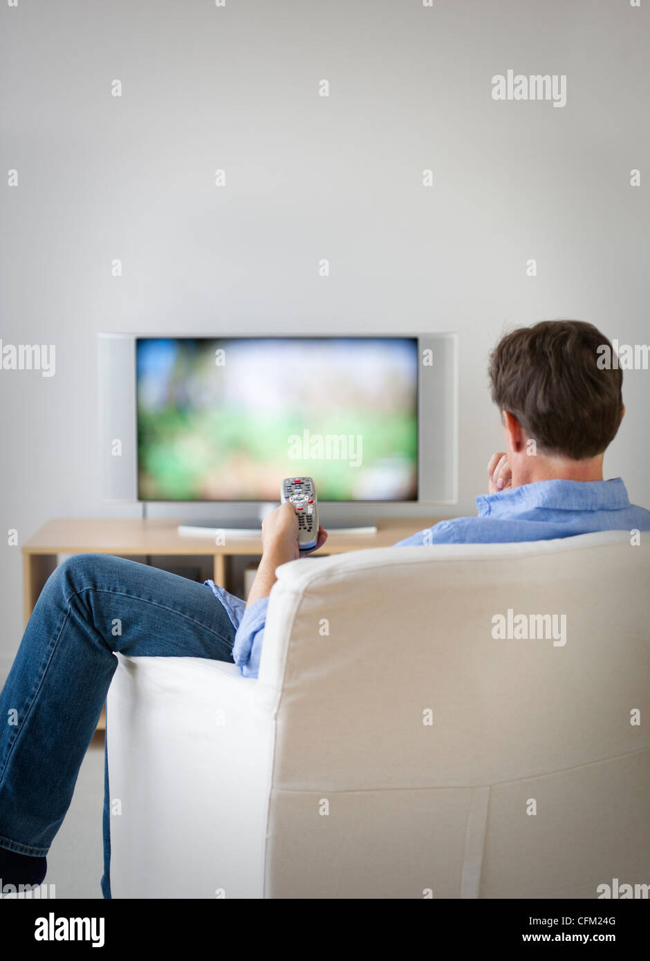 Jersey City, New Jersey, Man watching tv in living room Stock Photo - Alamy