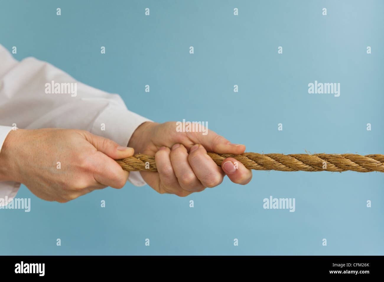Close up of man's hands pulling rope, studio shot Stock Photo - Alamy