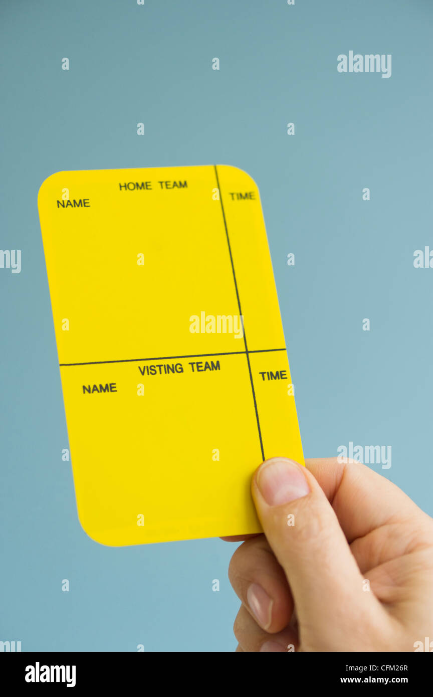Close up of man's hand showing yellow card, studio shot Stock Photo - Alamy