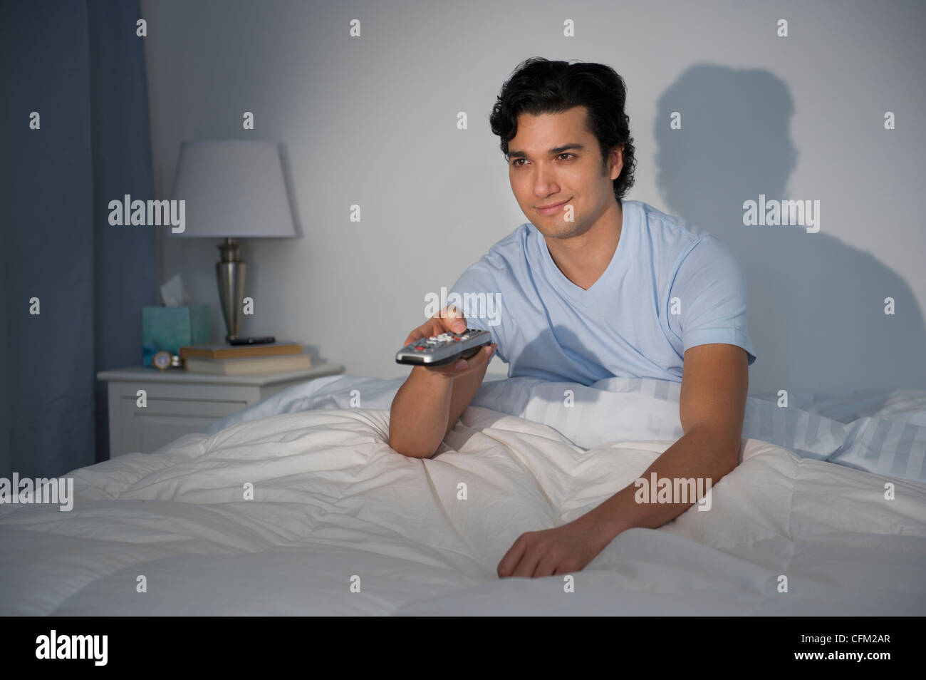 USA, New Jersey, Jersey City, Man watching tv in bed Stock Photo - Alamy