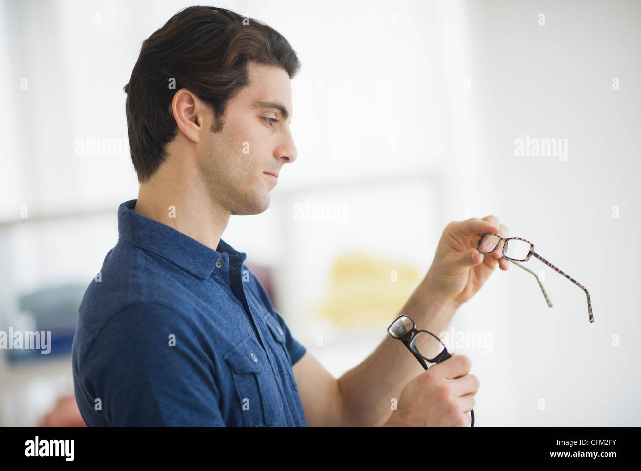 USA, New Jersey, Jersey City, Man looking at spectacles in store Stock ...