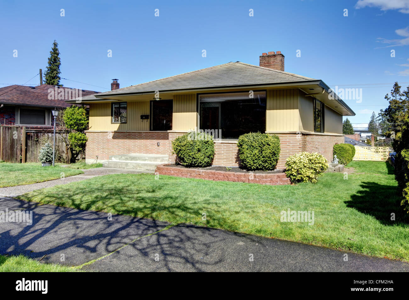Yellow brick American rambler exterior with front wood door Stock Photo ...