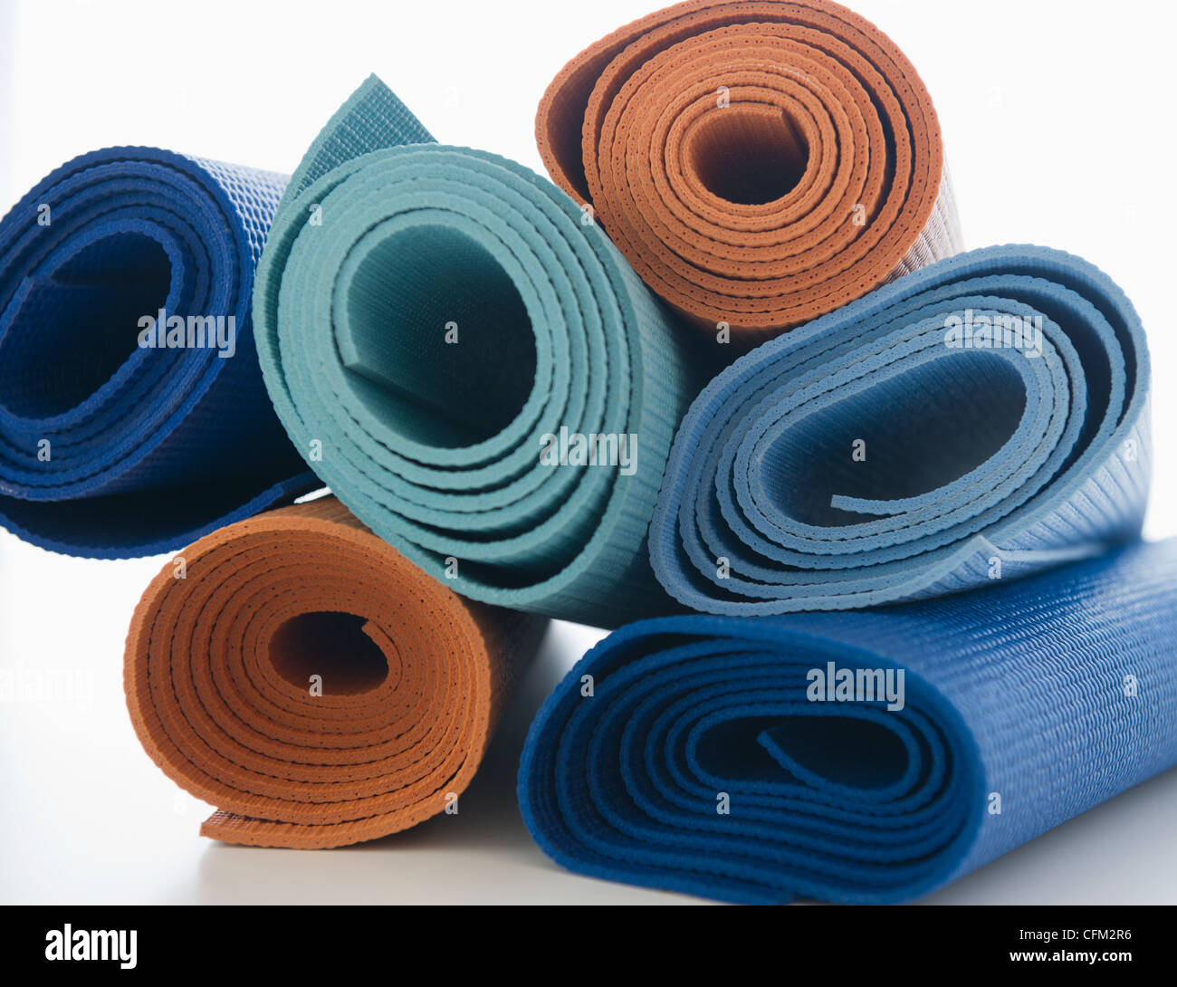 Stack of exercise mats on white background Stock Photo - Alamy