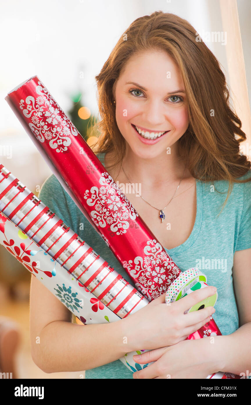 USA, New Jersey, Jersey City, Portrait of young woman holding wrapping ...