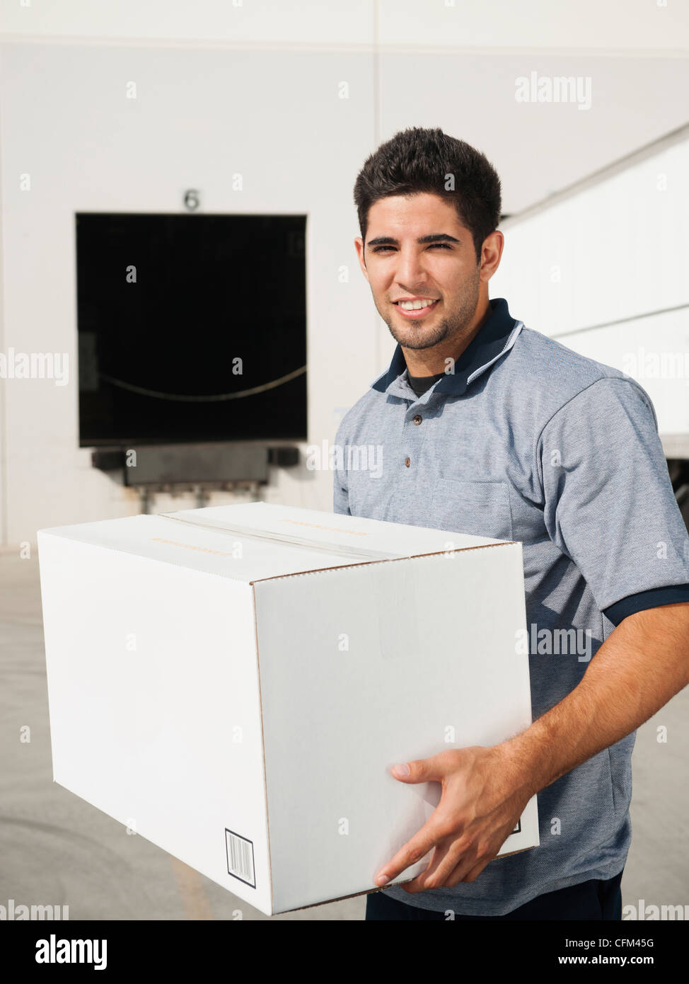 USA, California, Santa Ana, Man carrying box in warehouse Stock Photo ...