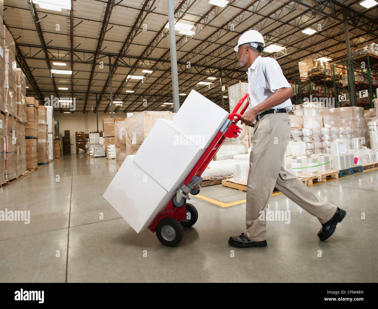 USA, California, Santa Ana, Man pushing hand truck in warehouse Stock ...