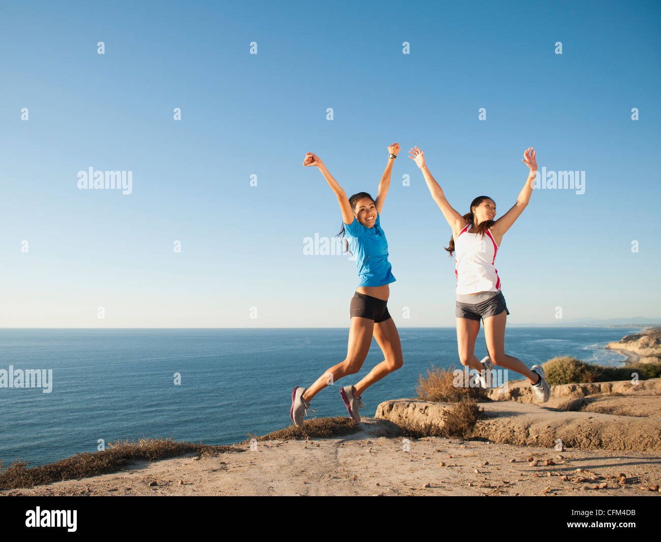 USA, California, San Diego, Two women jumping at sea coast Stock Photo ...
