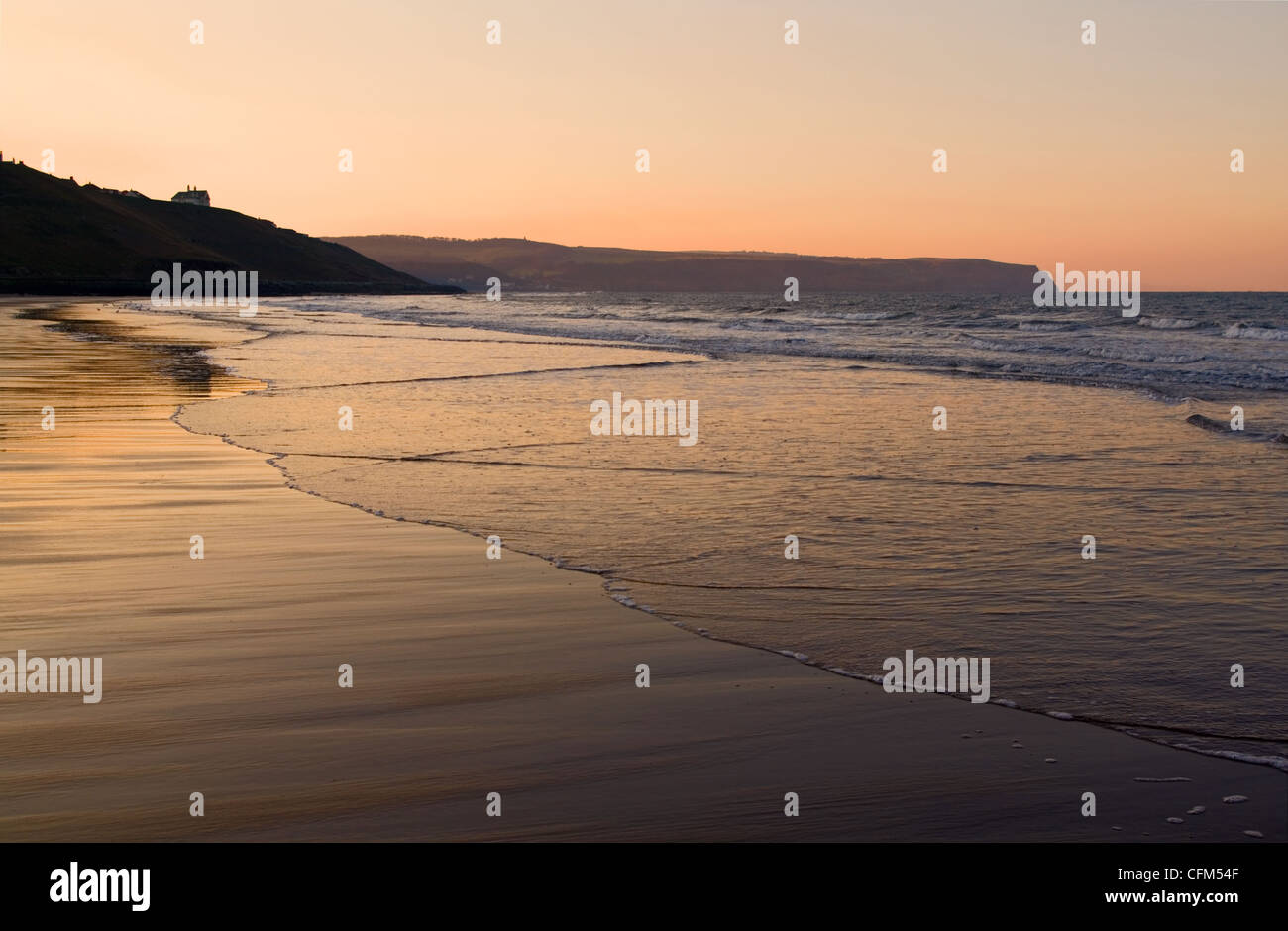 View along Whitby Sands below West Cliff towards Sandsend, winter dusk ...