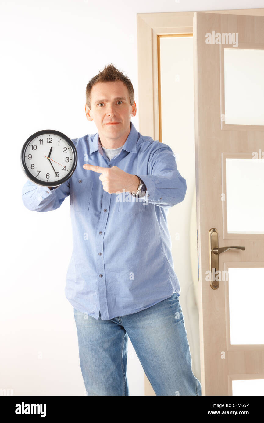 Angry man showing a clock. Common situation when a woman prepares ...