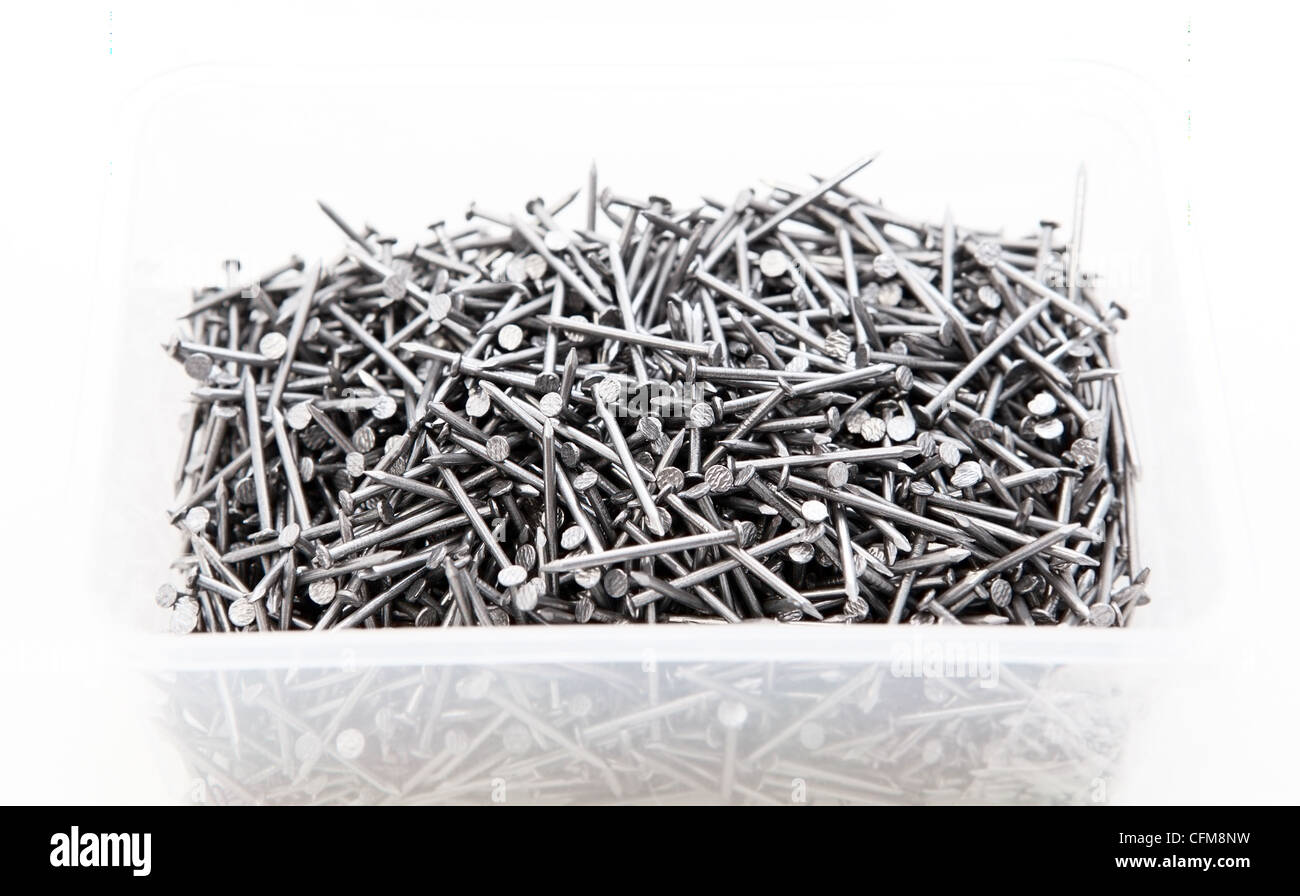 many metal nails in transparent box over white background Stock Photo ...