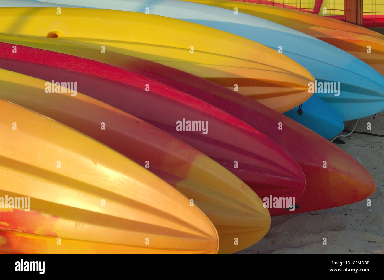 Plastic surfboards in primary colours, red, blue, yellow, make a ...