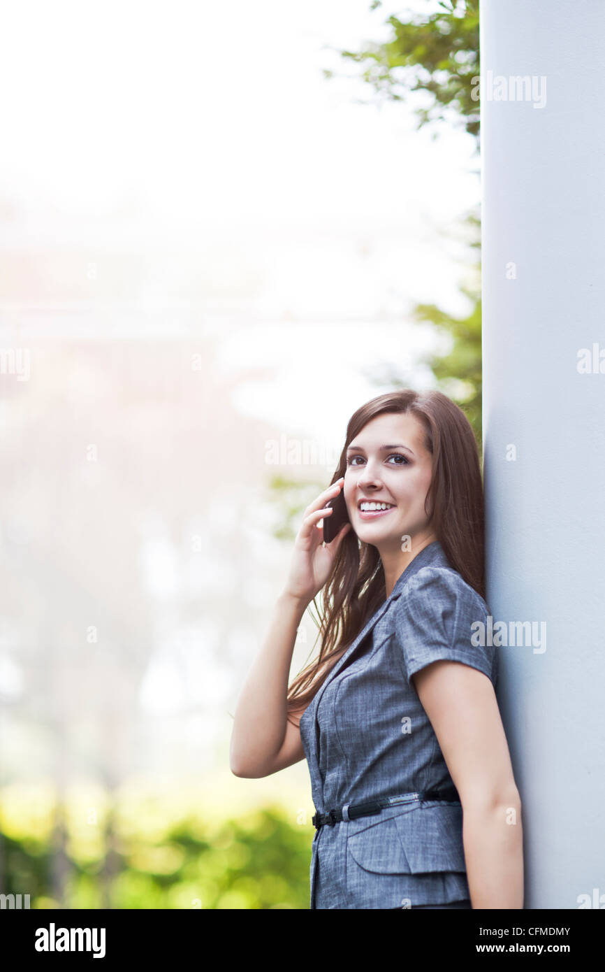 USA, Seattle, Young woman standing and talking via phone Stock Photo ...