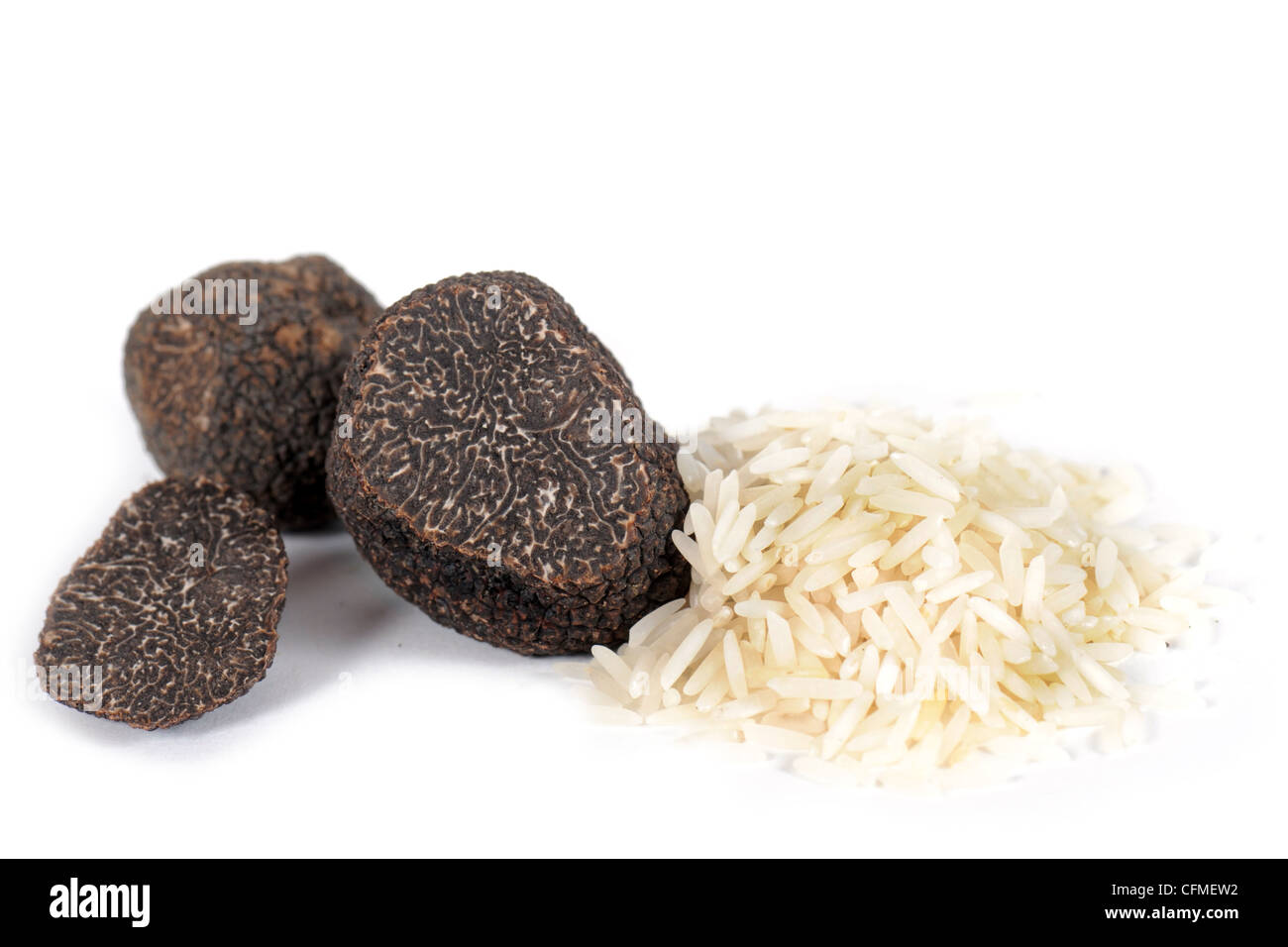 black truffles (tuber melanosporum)with rice in front of a white ...