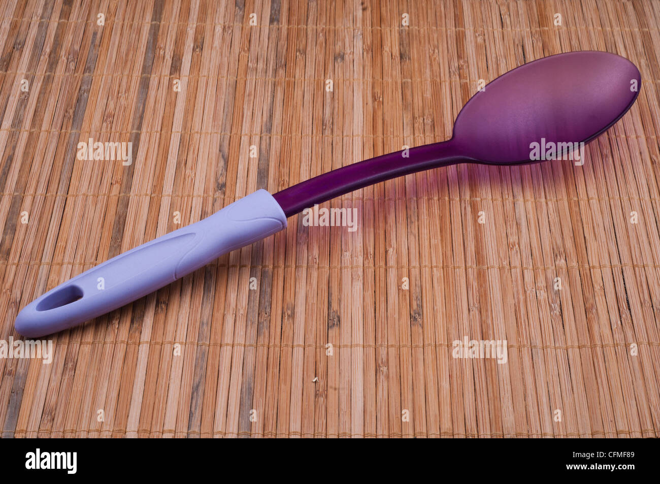 Purple kitchen spoon in Bamboo isolated backgorund Stock Photo - Alamy