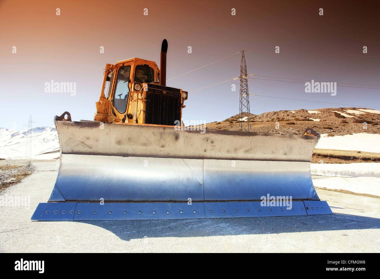 snow cleaning bulldozer on a mountain road in spring Stock Photo - Alamy