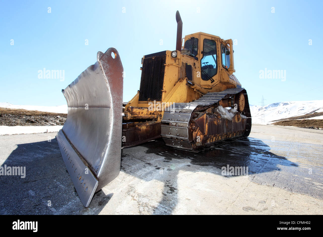 snow cleaning bulldozer on a mountain road in spring Stock Photo - Alamy