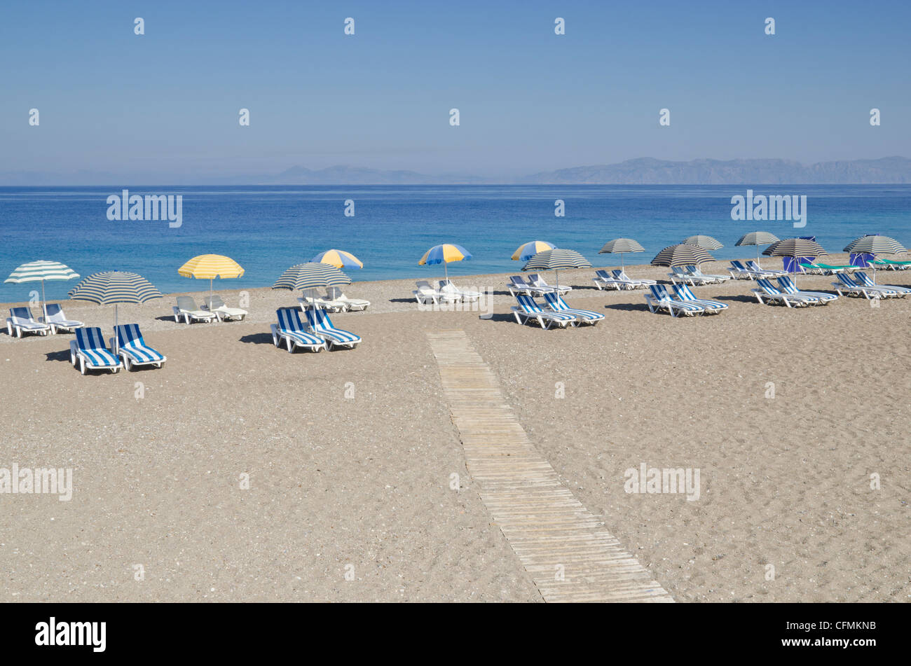 Sunloungers on an empty Greek beach on Rhodes Island, Greece Stock ...