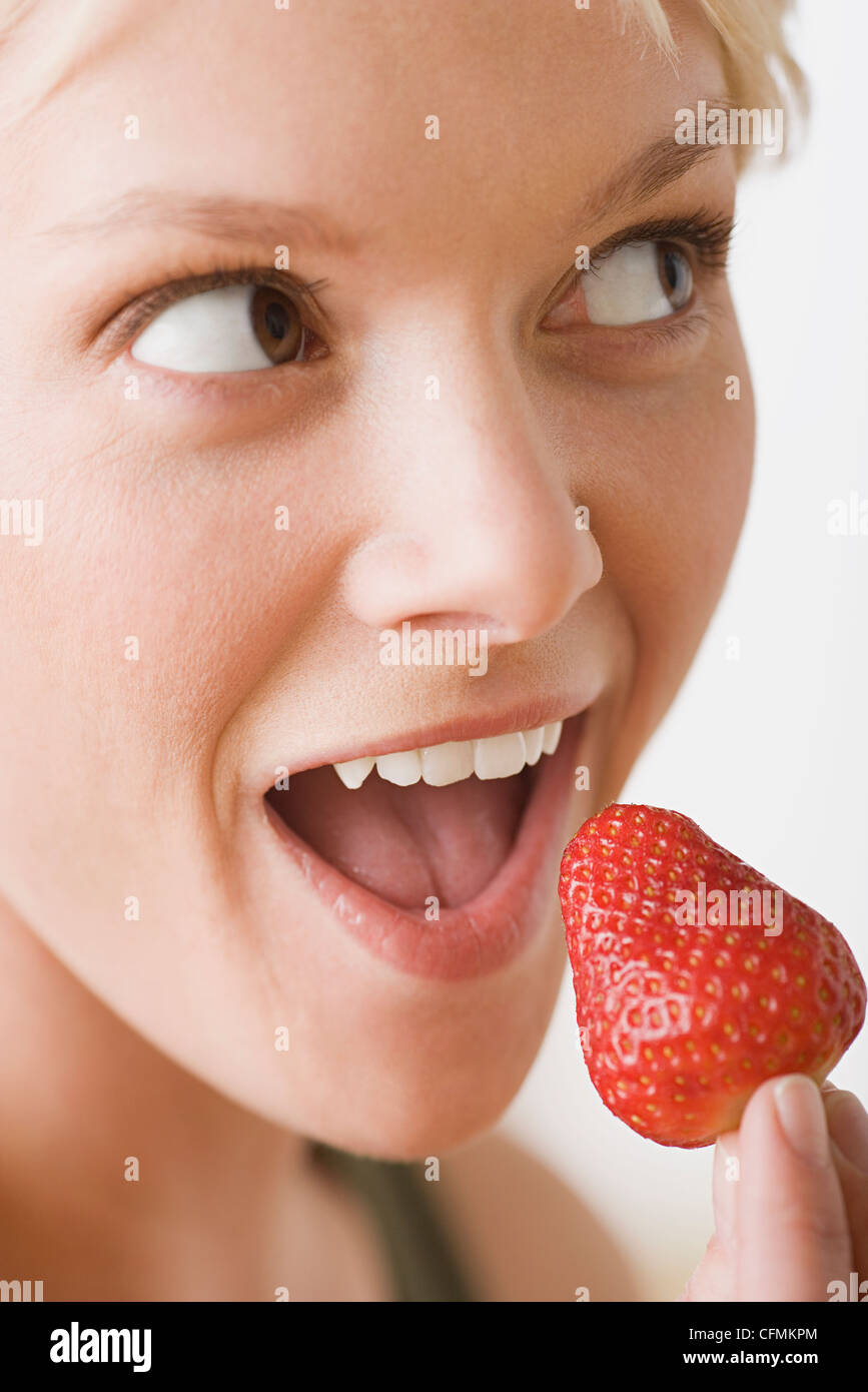 Woman eating strawberry Stock Photo - Alamy