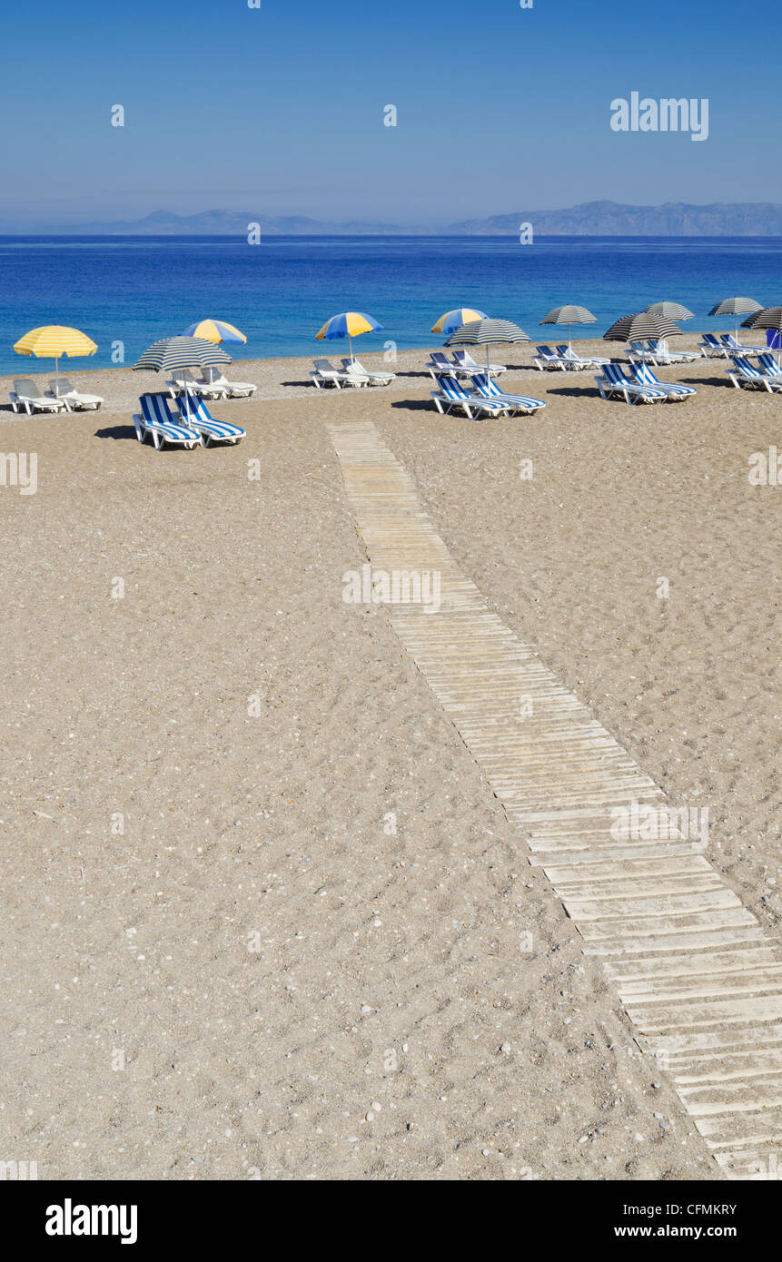 Sunloungers on an empty Greek beach on Rhodes Island, Greece Stock ...