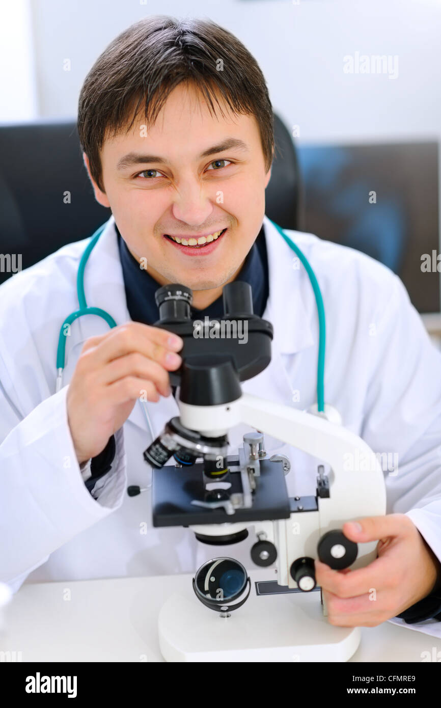 Smiling medical doctor working with microscope in laboratory Stock ...