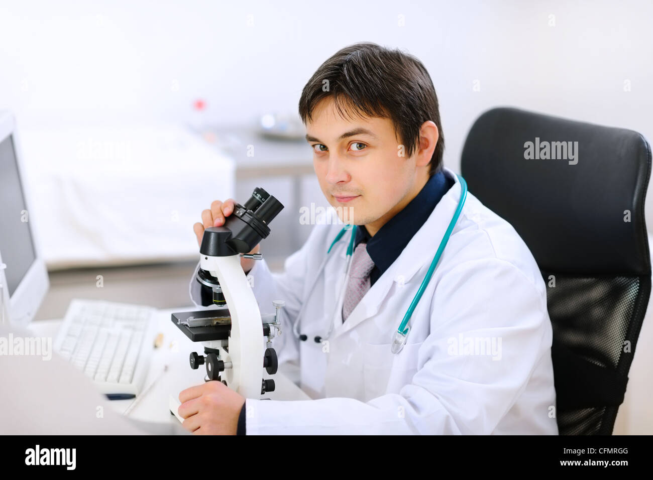Smiling doctor using microscope in laboratory Stock Photo - Alamy