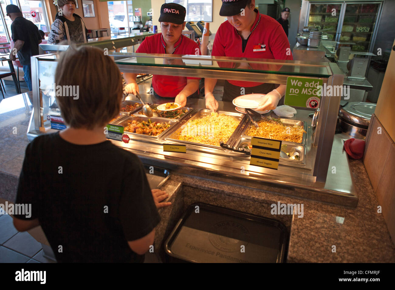 A nine year old boy orders a combination plate of Chinese fast food at ...