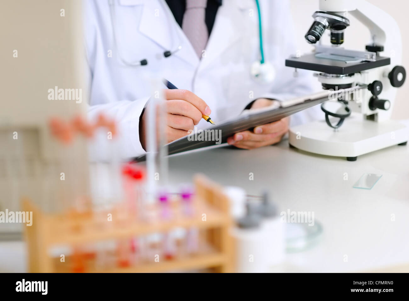 Medical doctor writing something in clipboard at office table. Close-up ...