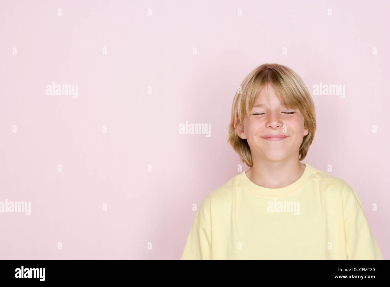 Studio shot portrait of teenage boy with eyes closed, head and ...