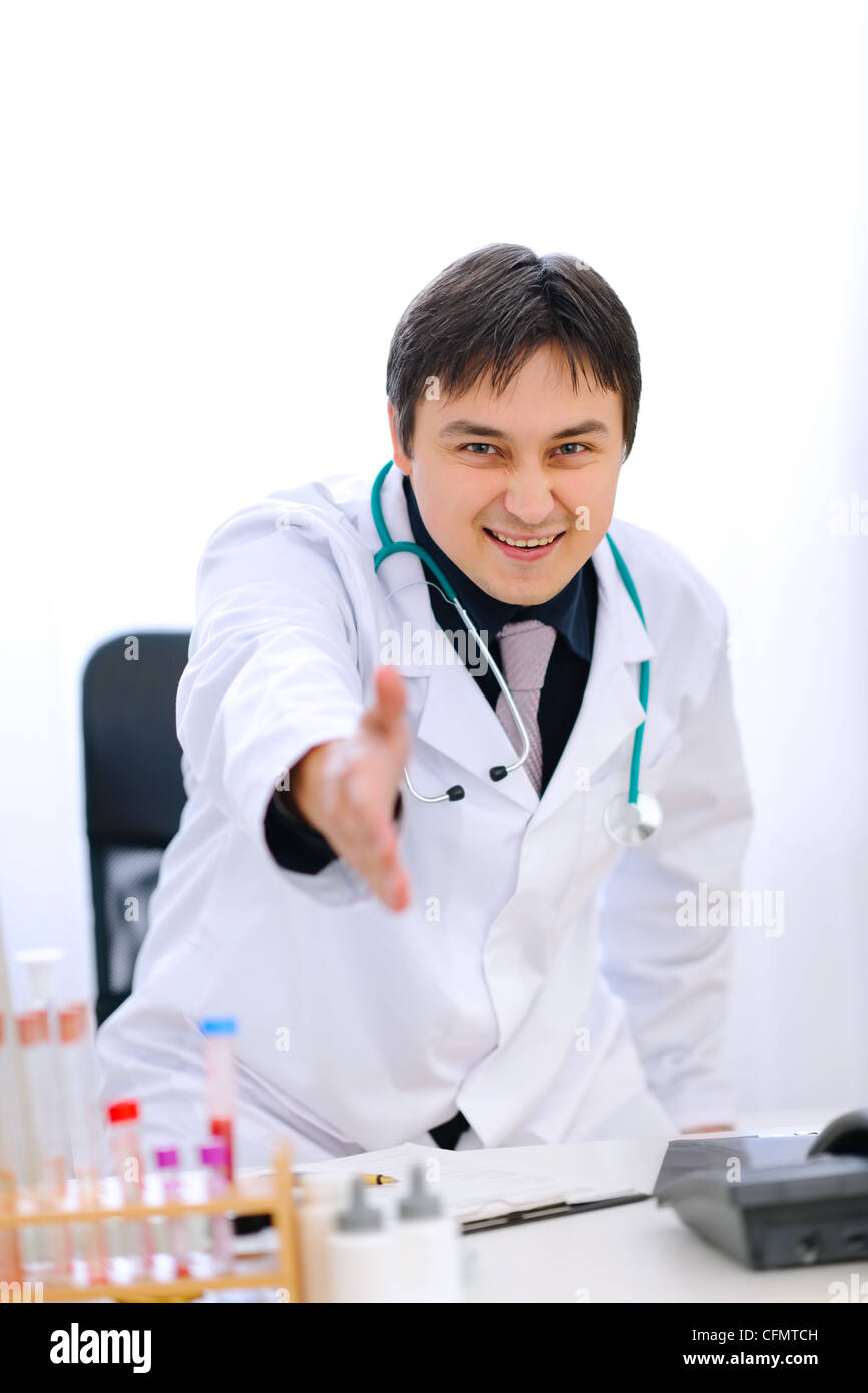 Smiling medical doctor stretches out hand for handshake in office Stock ...